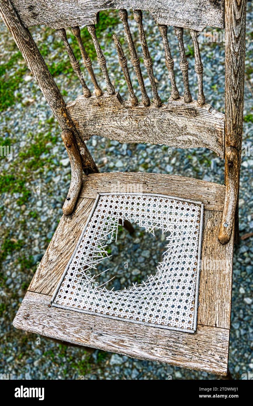 Old, damaged wicker bottom chair at a small roadside store dealing in ...