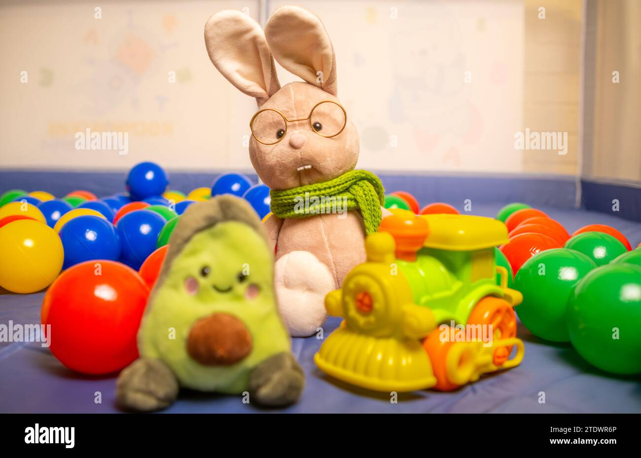 Bright children's toys. Soft toy rabbit with glasses and scarf, avocado ...