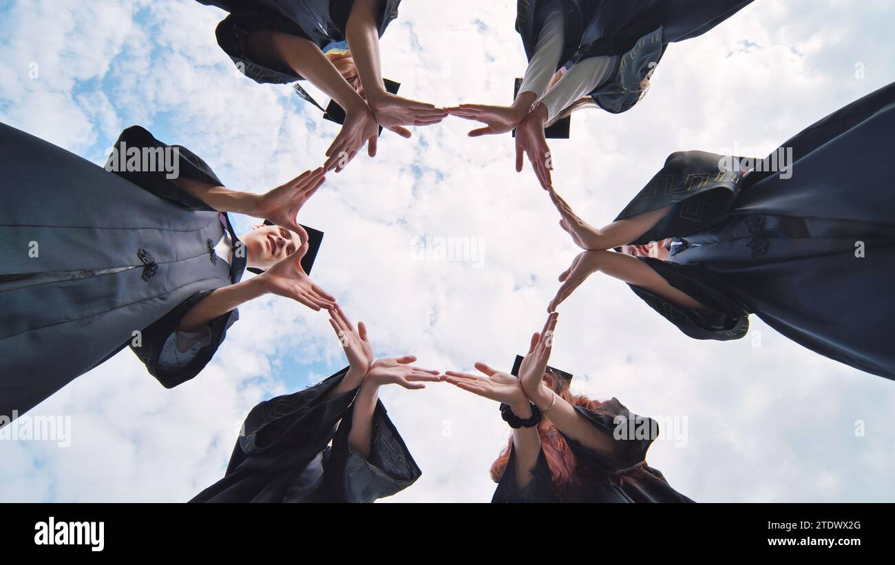 College graduates make a circle of their hands Stock Photo - Alamy