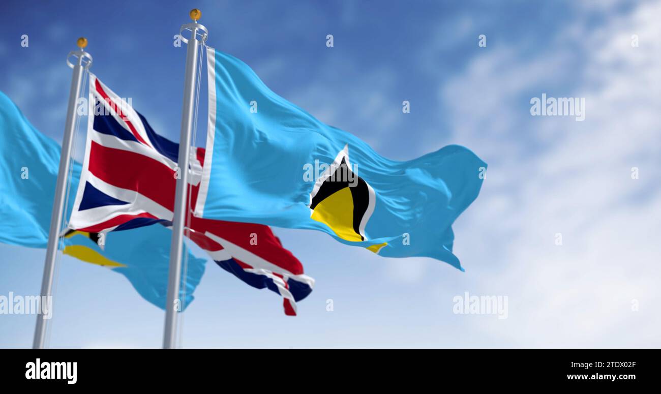 Saint Lucia national flags waving with United Kingdom flag on a clear ...
