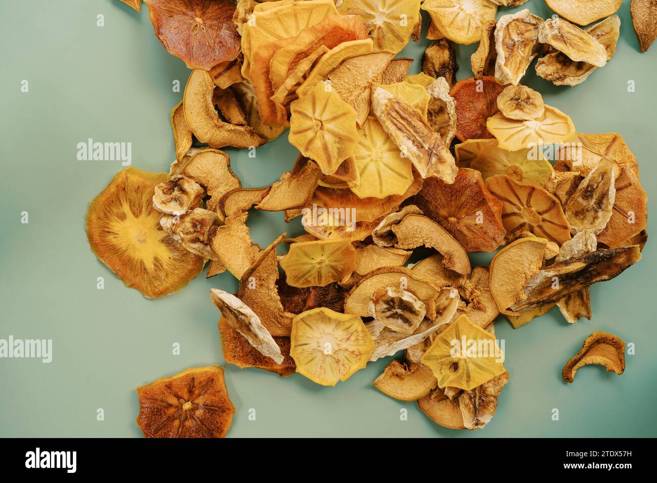 Mound of thin slices of dried fruits on a green background Stock Photo ...