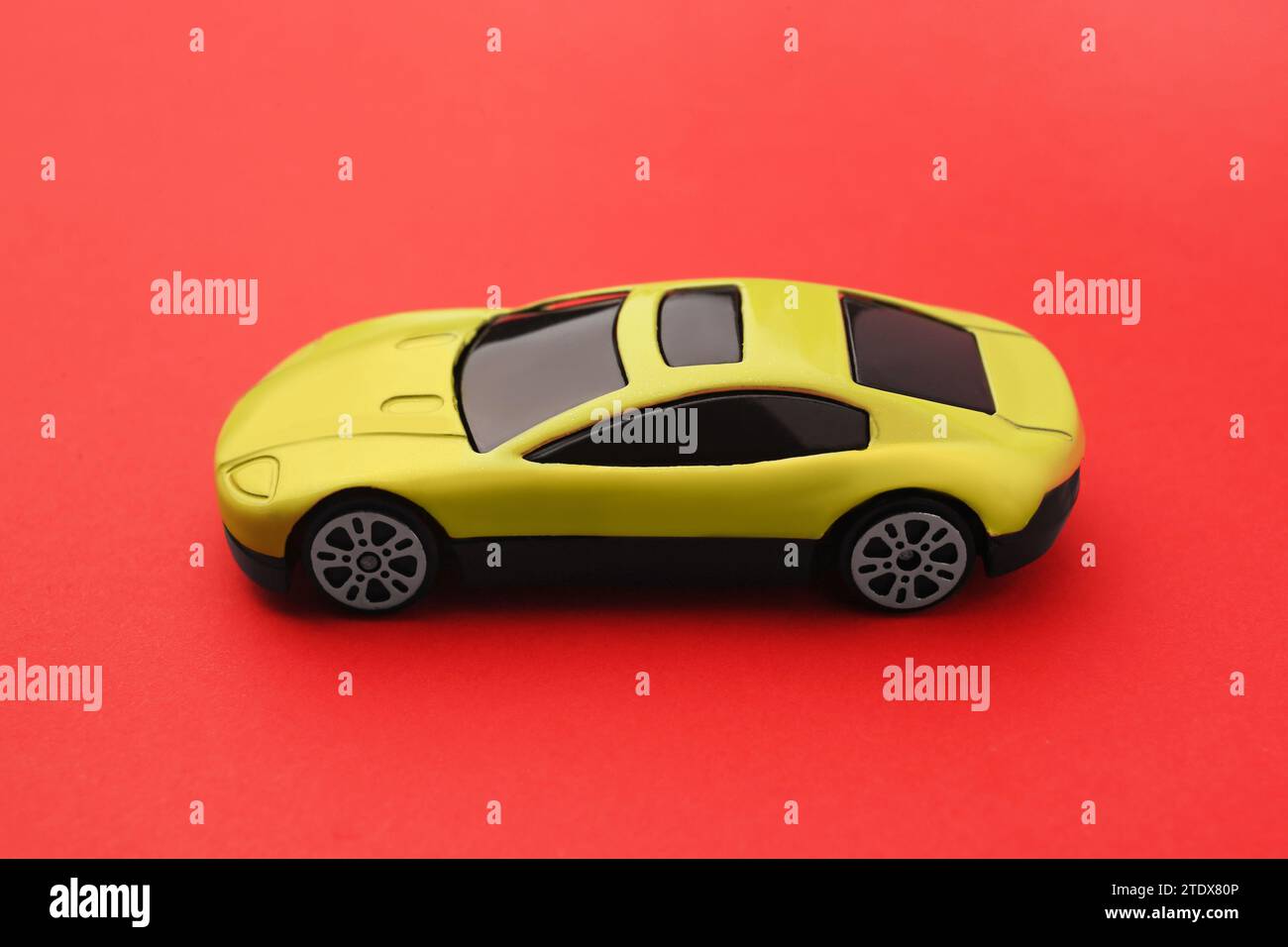 One yellow car on red background. Children`s toy Stock Photo - Alamy