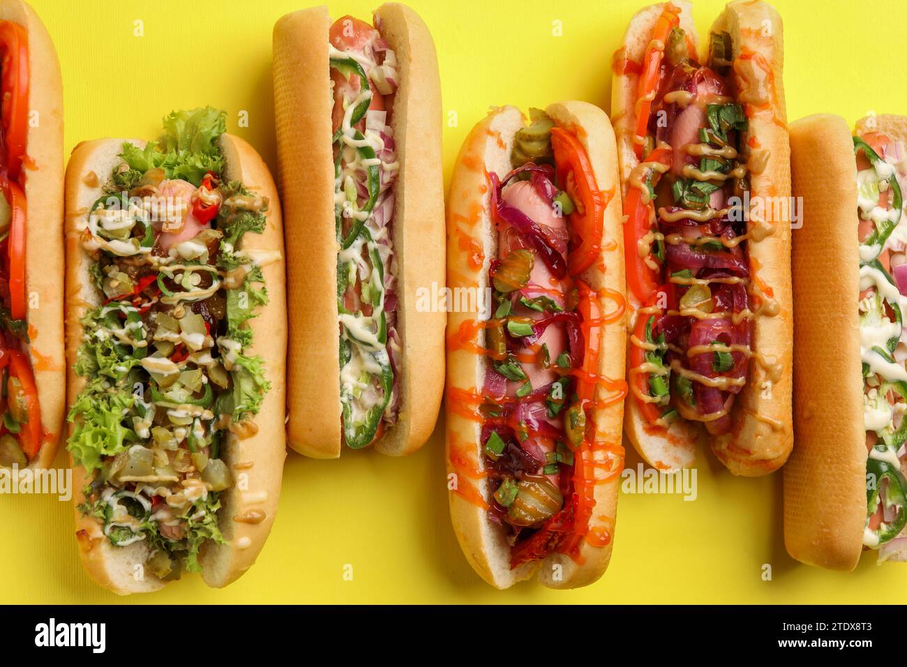 Delicious hot dogs with different toppings on yellow background, flat ...