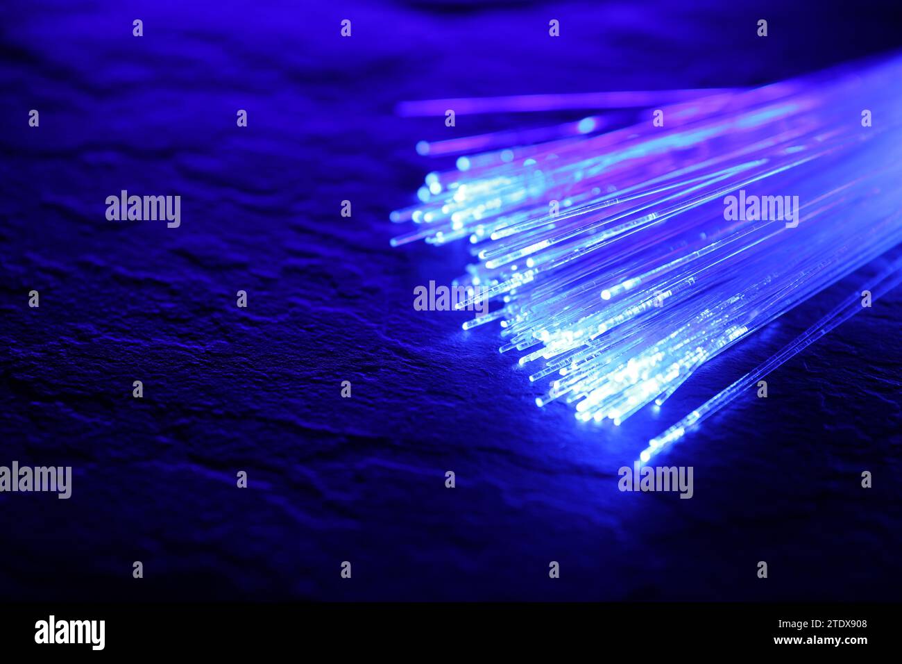 Optical fiber strands transmitting color light on textured background ...