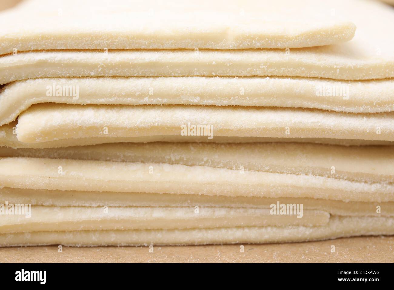 Stacked sheets of raw puff pastry dough as background, closeup Stock ...