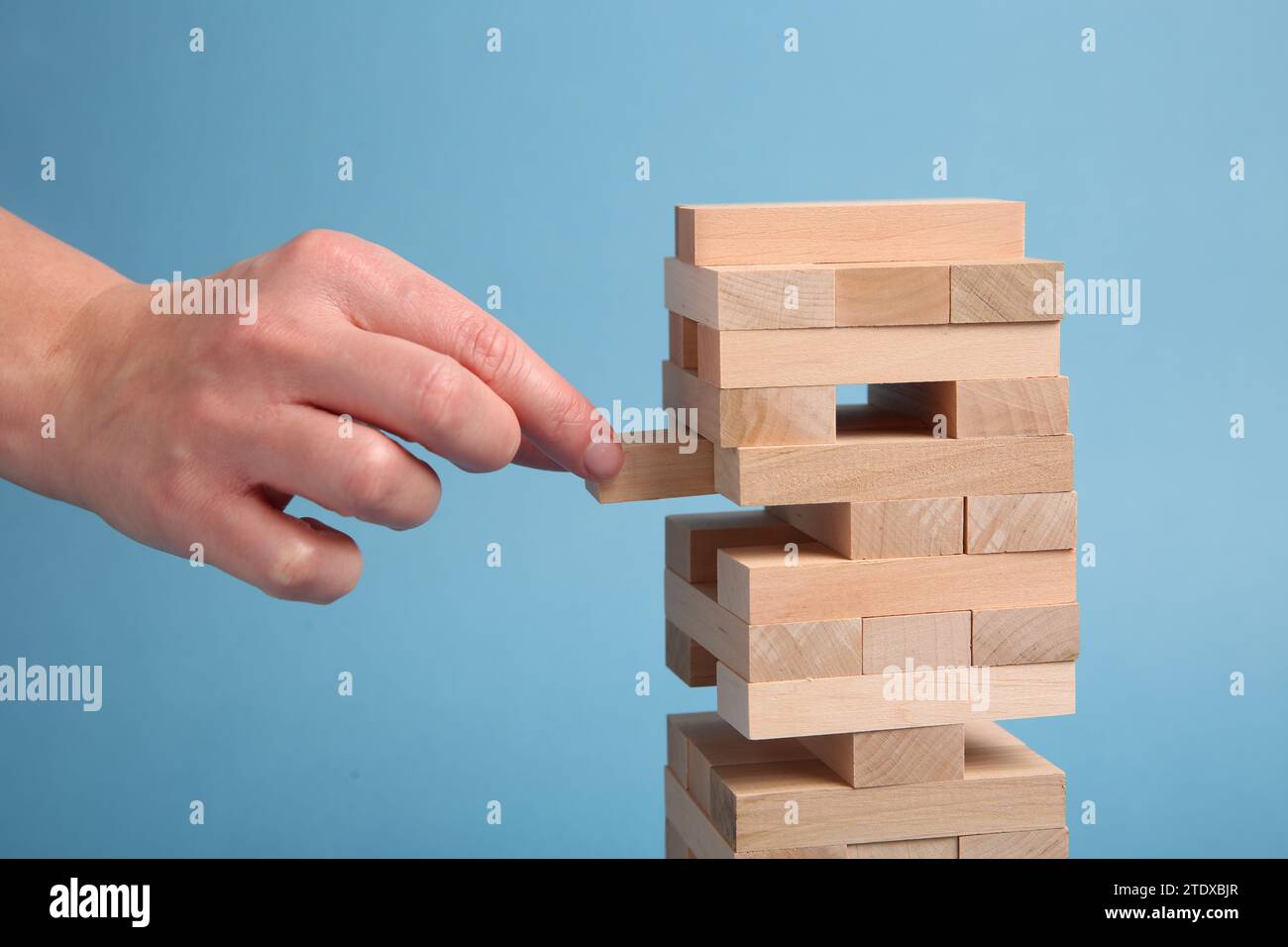 Woman playing Jenga on light blue background, closeup Stock Photo - Alamy