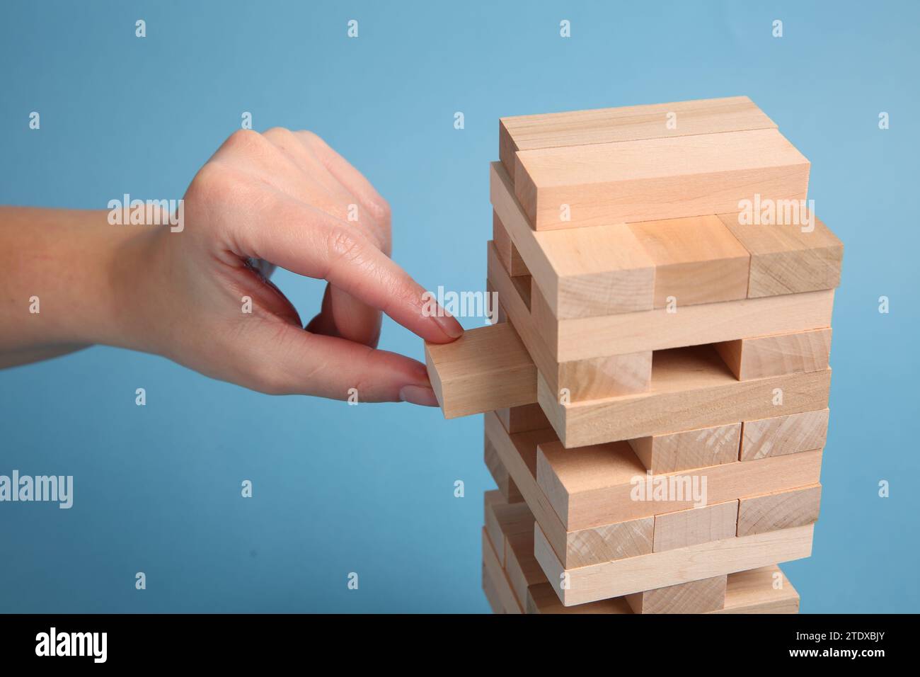 Woman playing Jenga on light blue background, closeup Stock Photo - Alamy