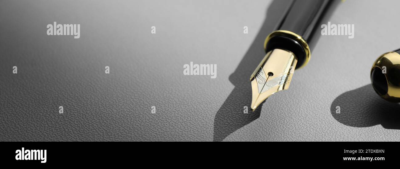 Fountain pen on grey table, closeup. Banner design with space for text ...