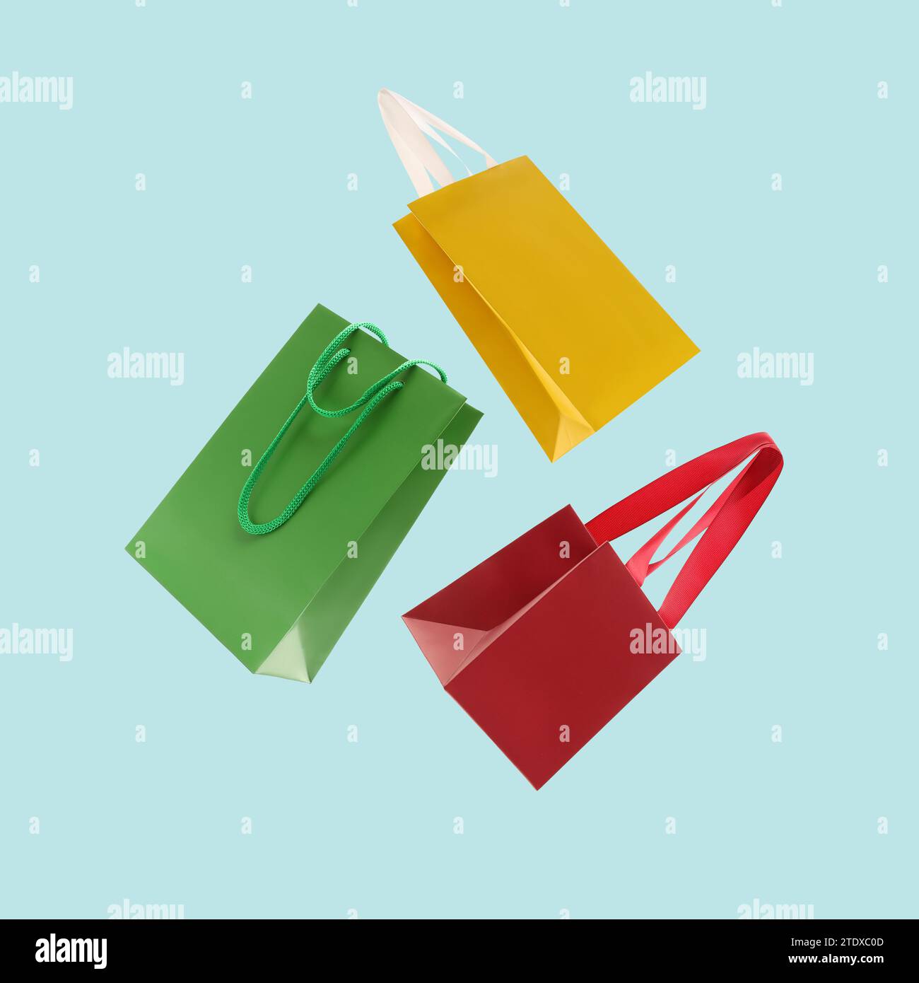 Colorful shopping bags falling on light blue background Stock Photo - Alamy