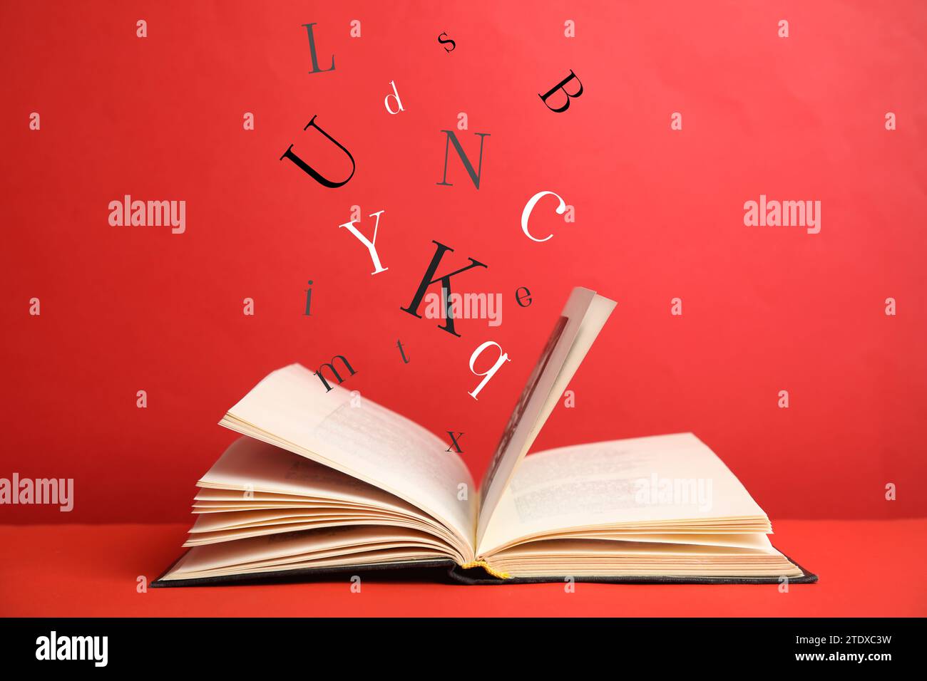 Open book with letters flying out of it on red background Stock Photo ...