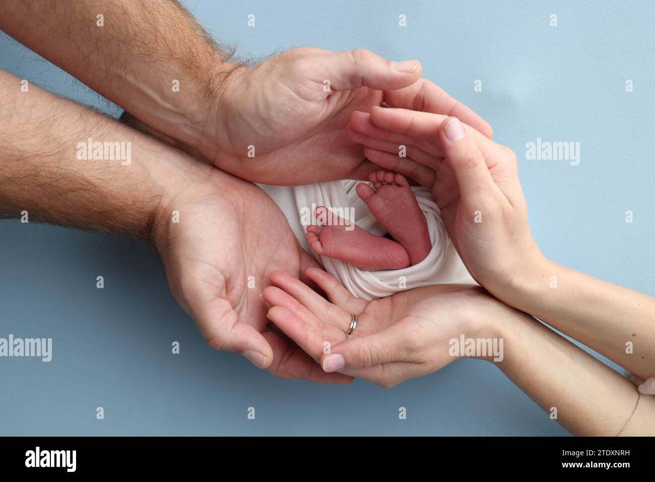 The palms of the parents, father and mother hold the legs, feet of ...