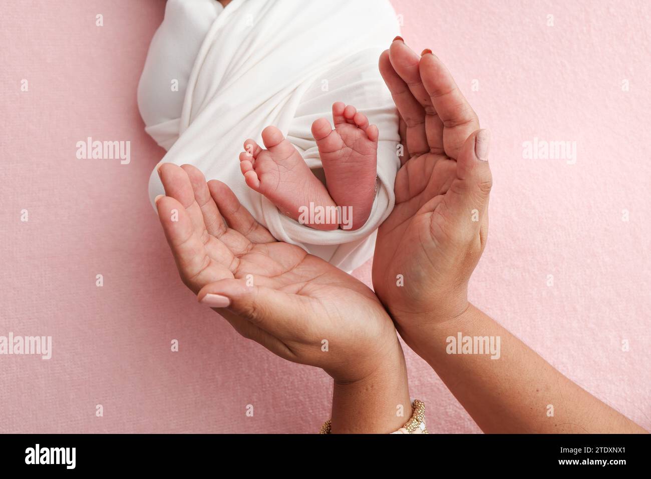 The palms of the parents, father and mother hold the legs, feet of ...