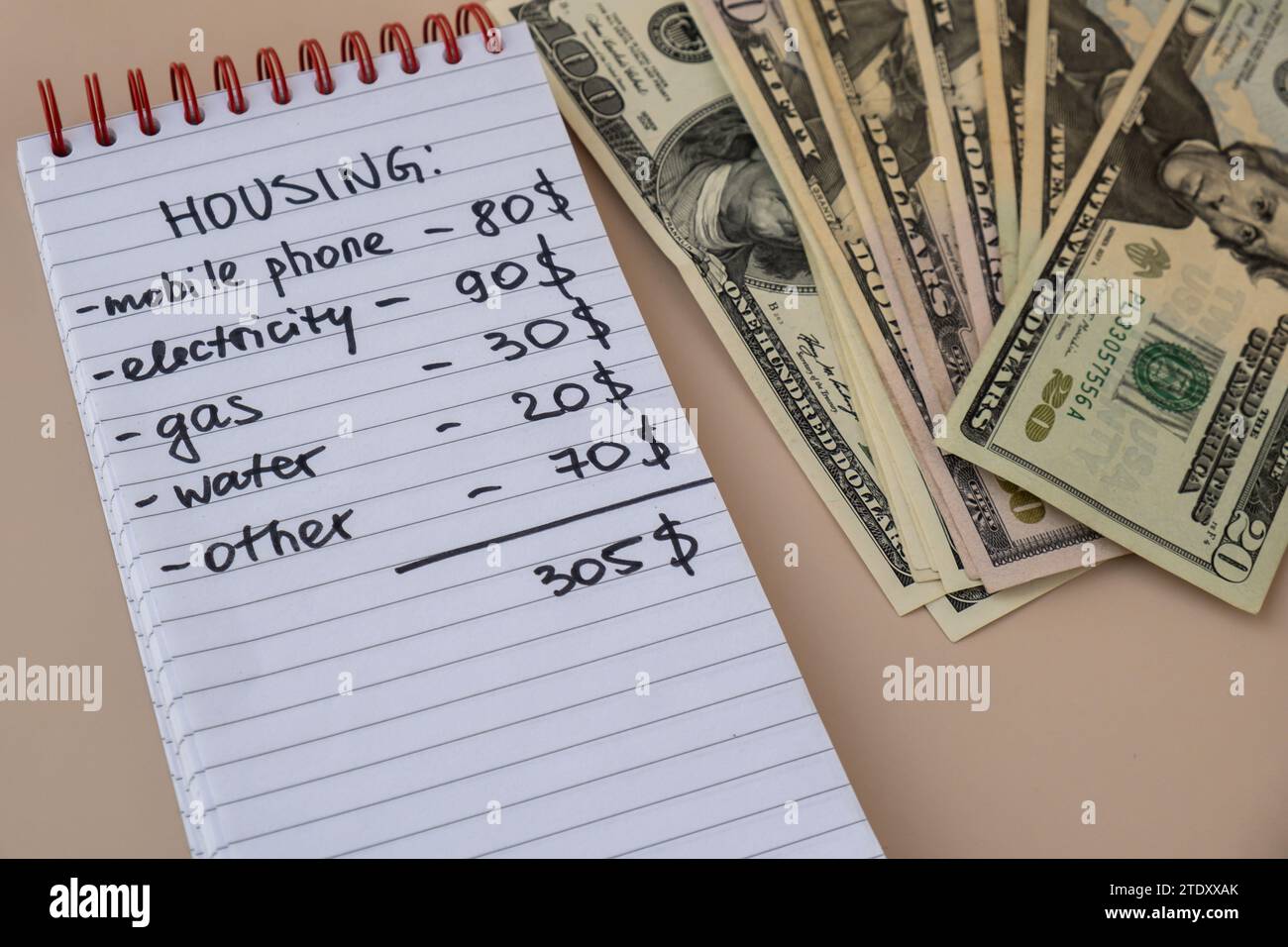 Dollar cash money with notebook handwritten housing expenses. Counting ...