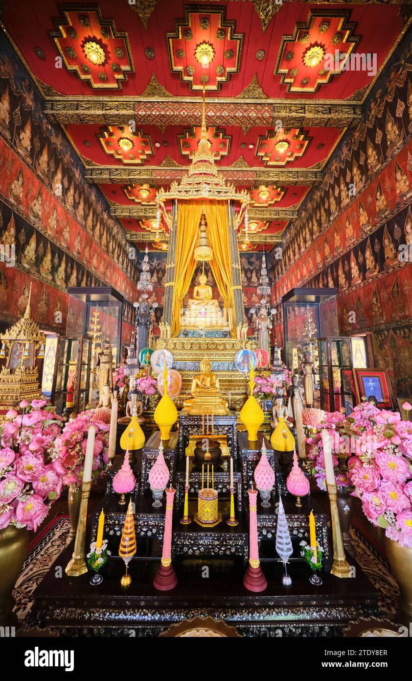 A view of the rich, fancy, yellow, gold altar with sitting Buddha ...