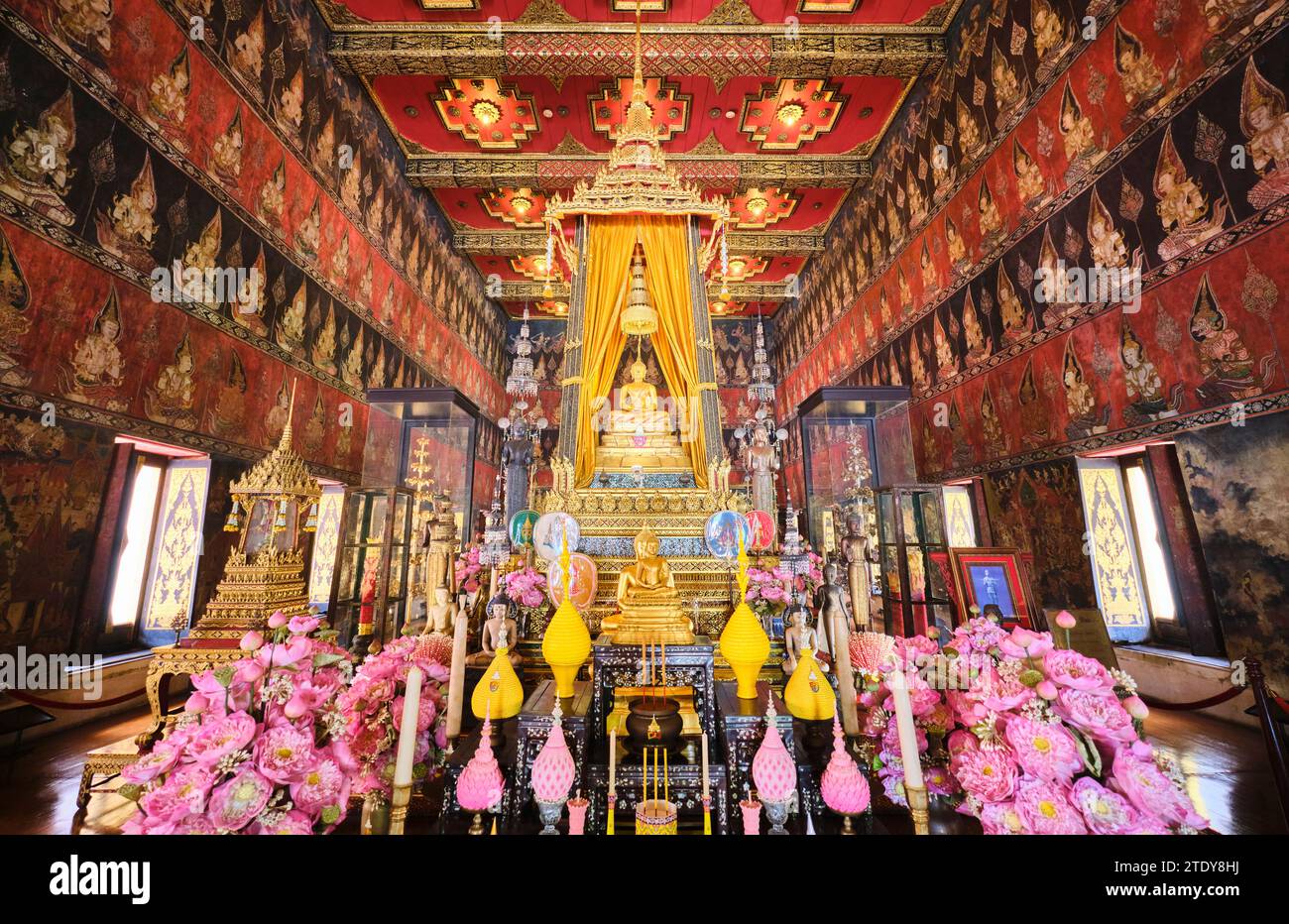 A view of the rich, fancy, yellow, gold altar with sitting Buddha ...
