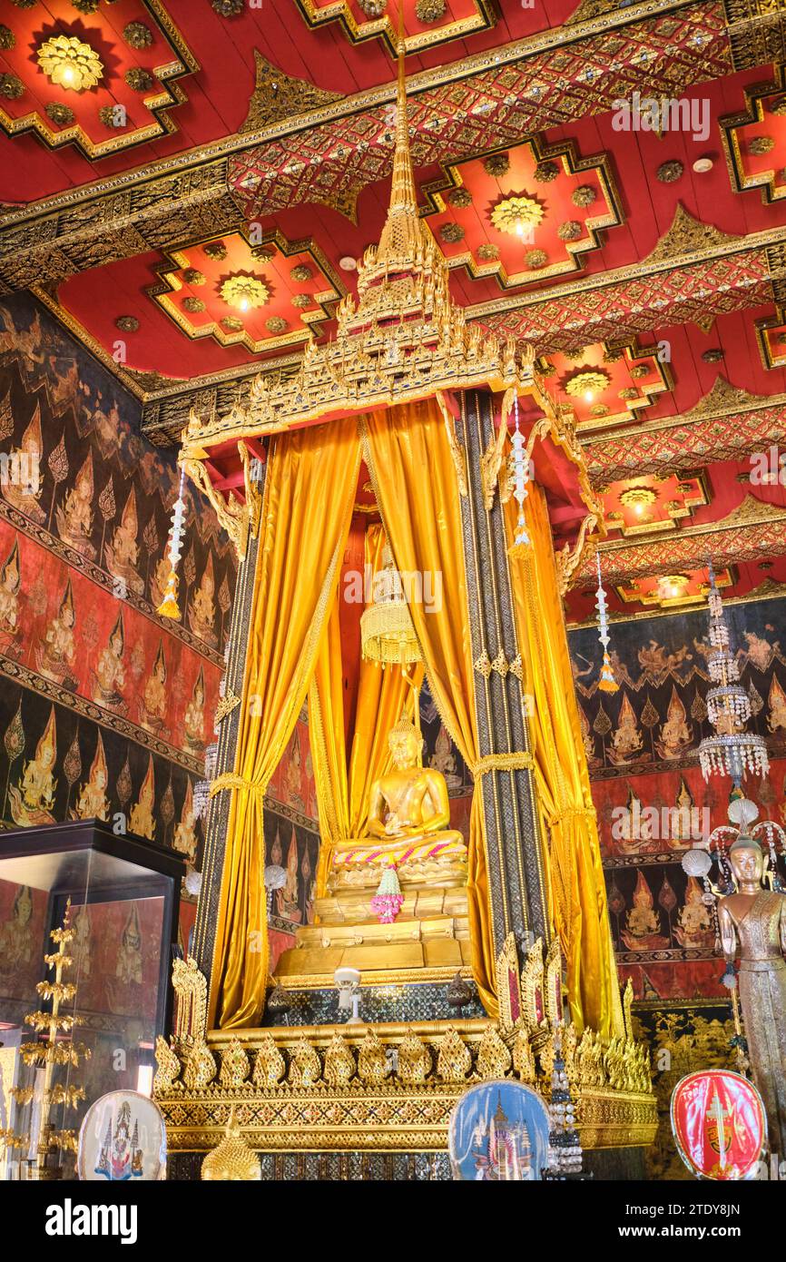 A view of the rich, fancy, yellow, gold altar with sitting Buddha ...