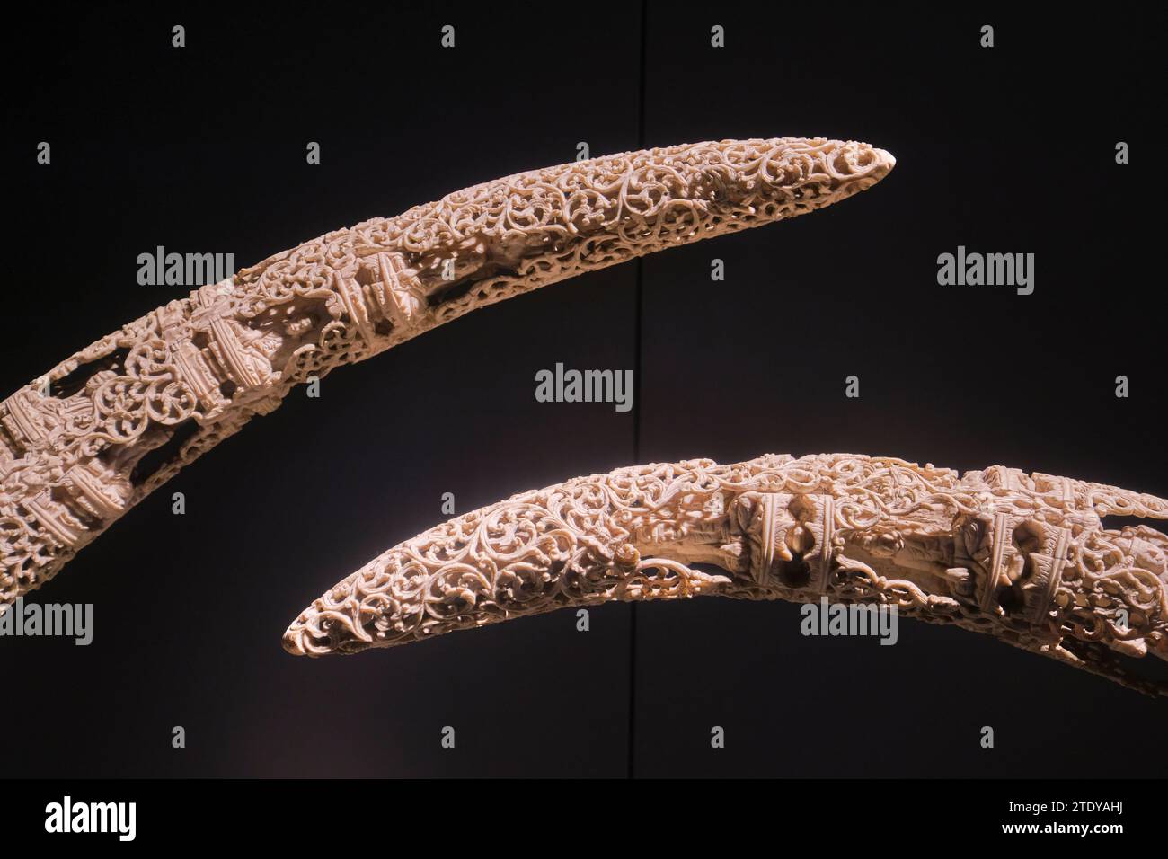 A detail in a display of intricately carved ivory elephant tusks ...