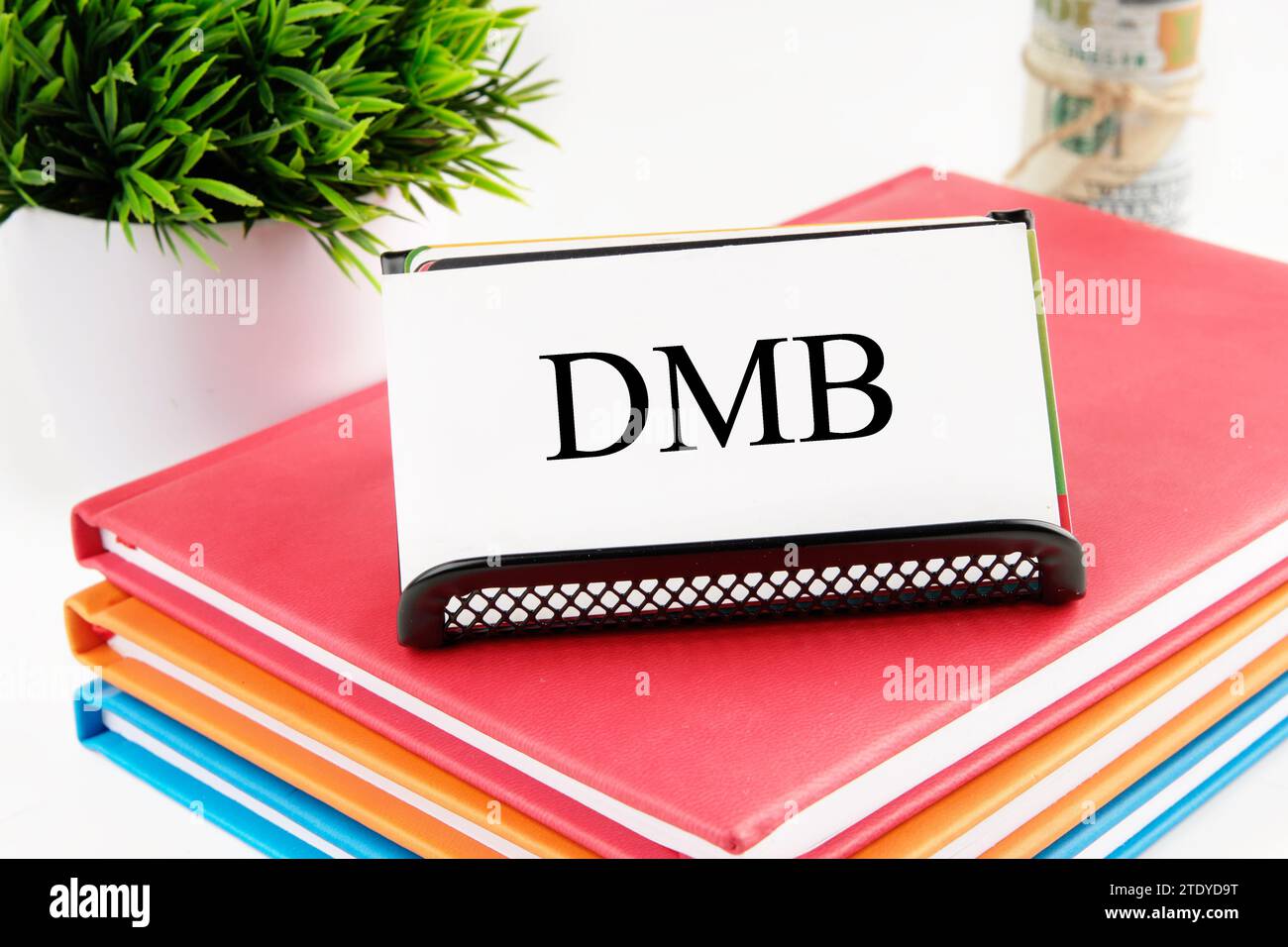 DMB text on a white business card standing on a stand on notebooks ...