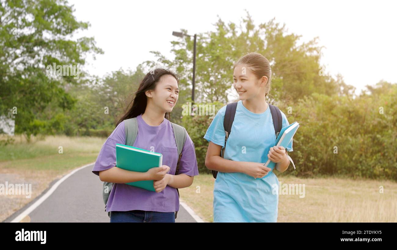 Happy student girls walking and talking in the school Stock Photo - Alamy
