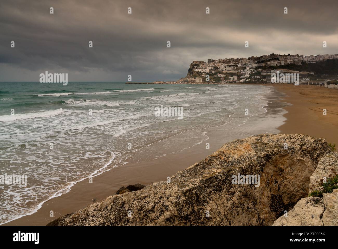 view of Peschici Bay and clifftop town under a rainy and overcast sky ...