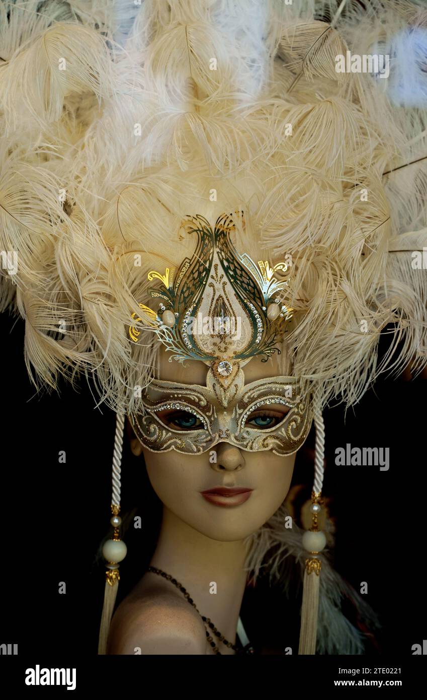 venetian mask is worn on a mannequin in a store window on a black ...
