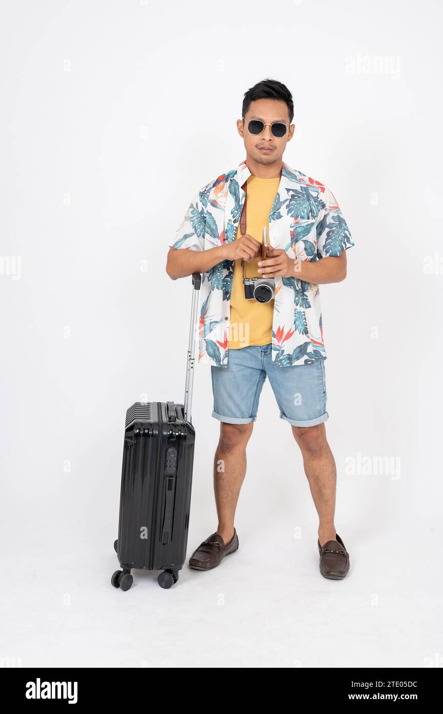 A handsome Asian man in sunglasses and summer clothes is standing on an ...