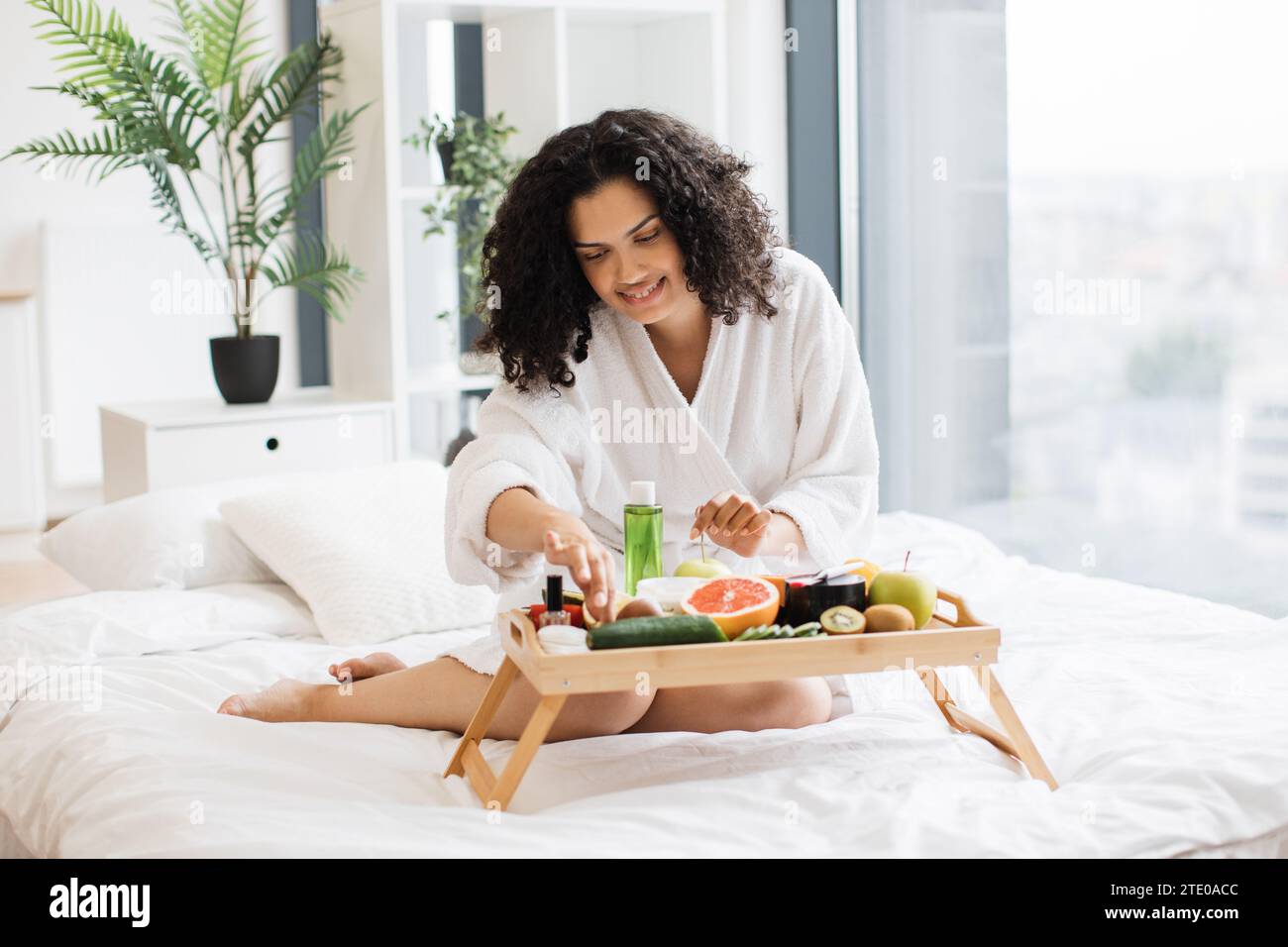 African lady touching to fruits and cosmetic containers on tray table ...