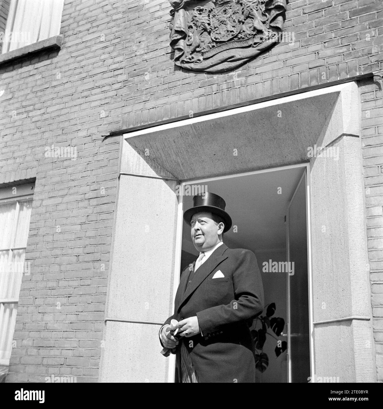 Director Jan van Abbe in a coat with a top hat in a doorway ca. 1950 ...