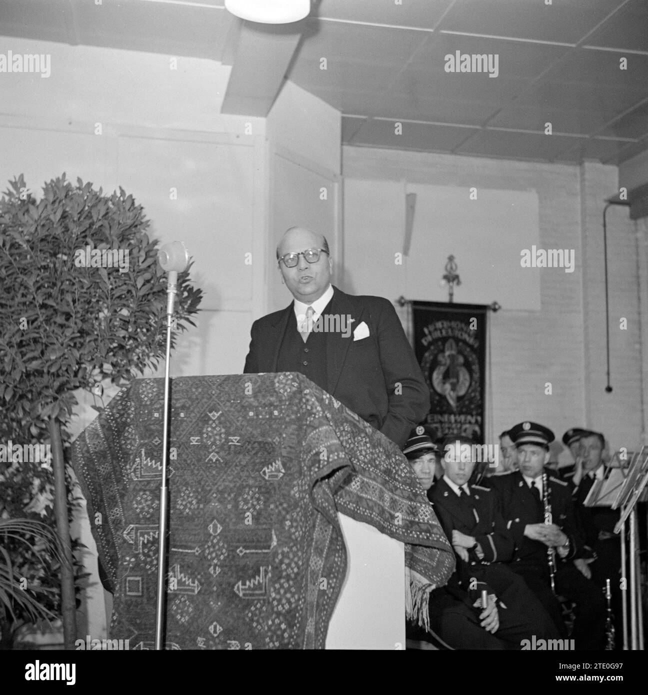 Man behind a carpeted lectern, in the background a band ca. 1950 Stock ...
