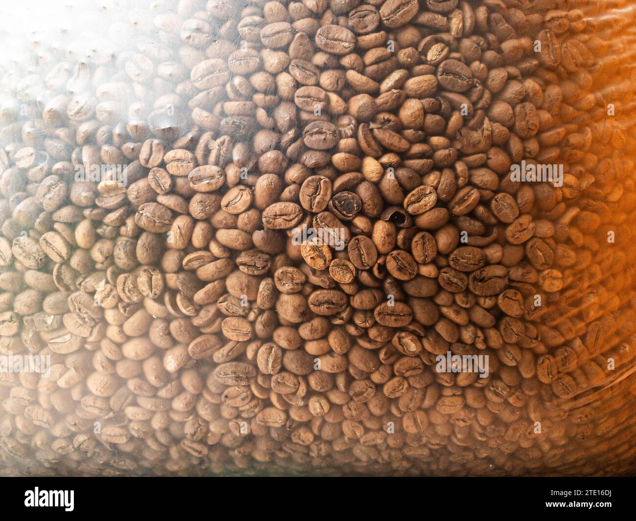 Close up coffee beans in plastic storage background Stock Photo - Alamy