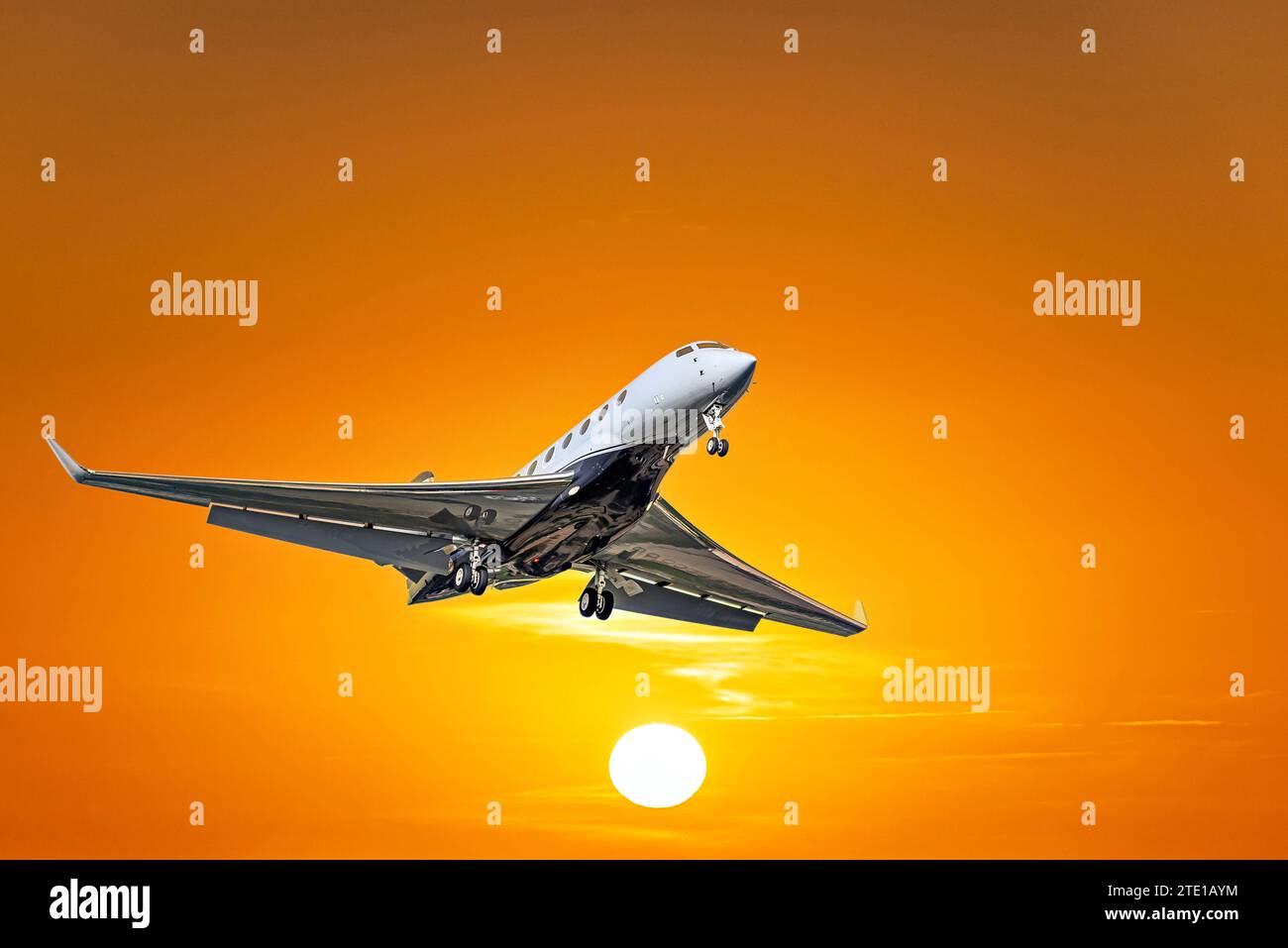 Private business plane flying under orange sunset sky Stock Photo - Alamy