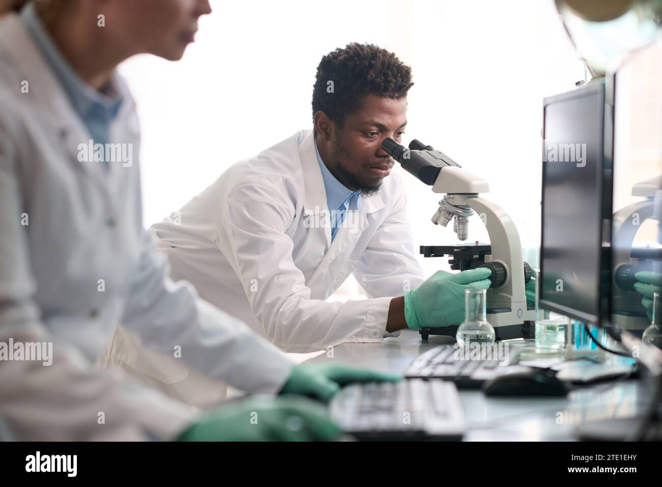 Laboratory Worker Looking through Microscope Stock Photo - Alamy