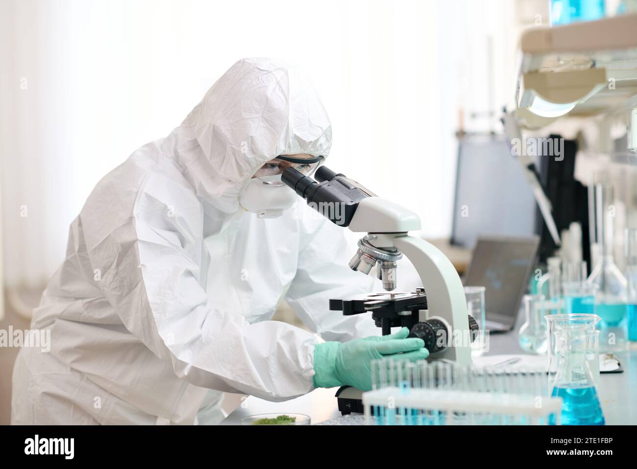 Scientist Wearing Protective Gear Using Microscope Stock Photo - Alamy