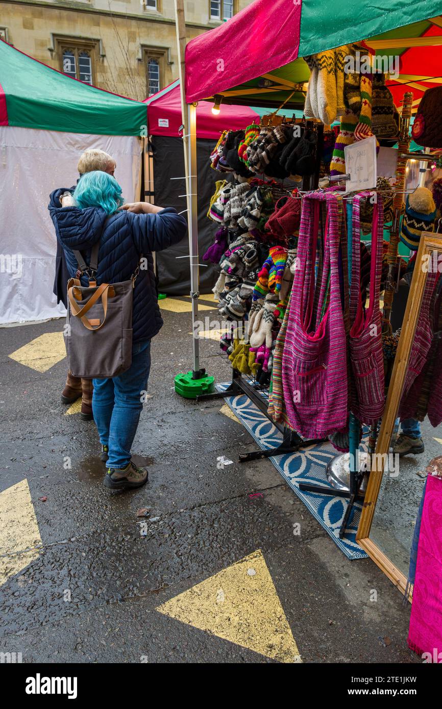 two women examine goods on a Christmas market stall in Oxford, England ...