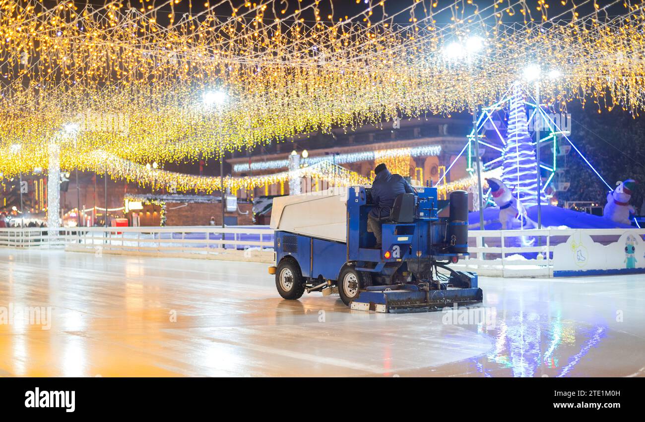 The ice rink in center of city park. Ice polishing with service machine ...