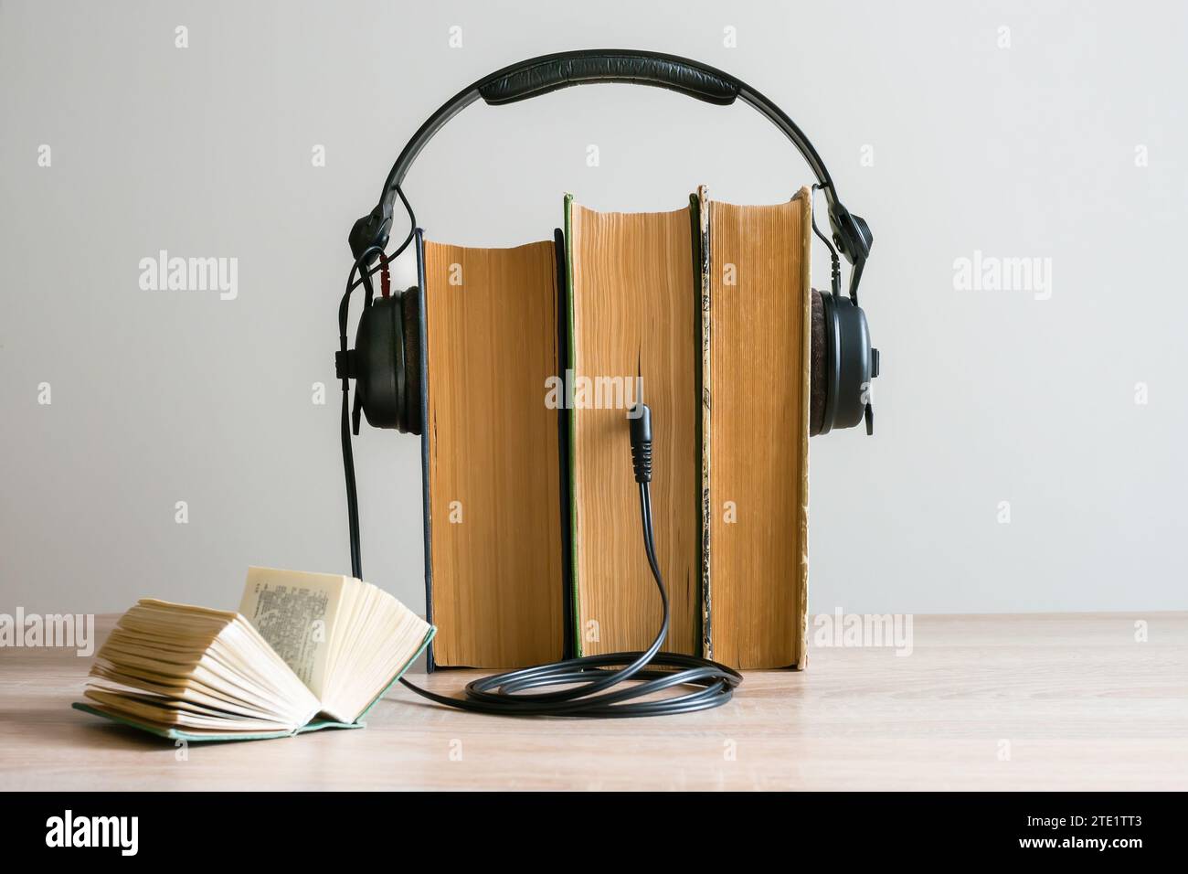 Books with headphones and a mini-jack plug inserted between the pages ...