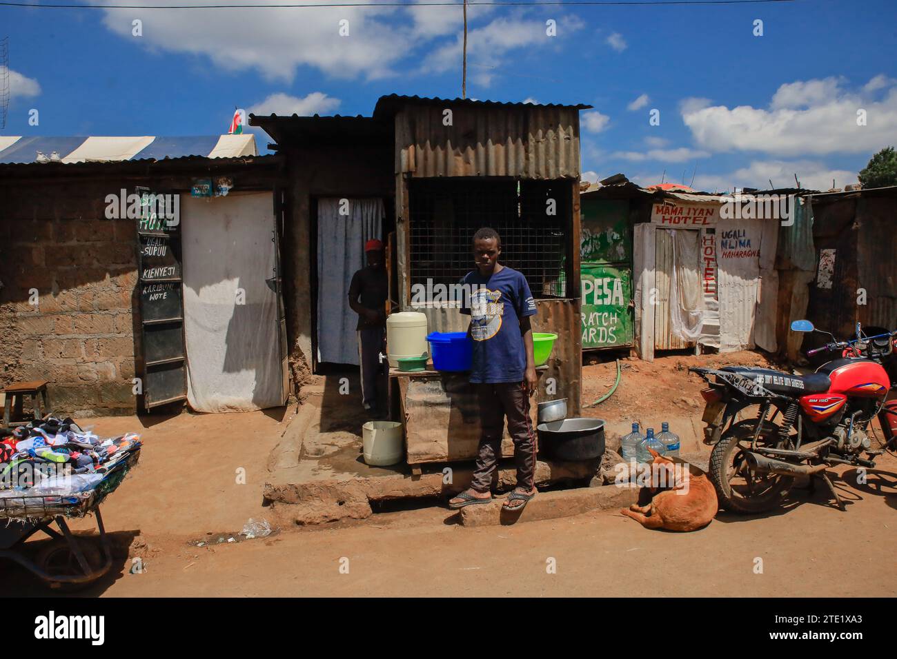 Residents waiting outside a mini restaurant in Kibera Slum, Nairobi. A ...