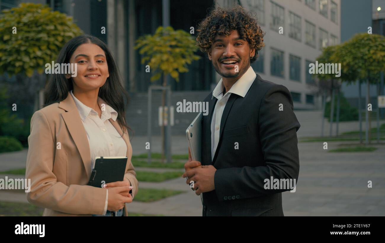 Indian businessman and Arabian businesswoman business partners colleagues people smiling looking ...