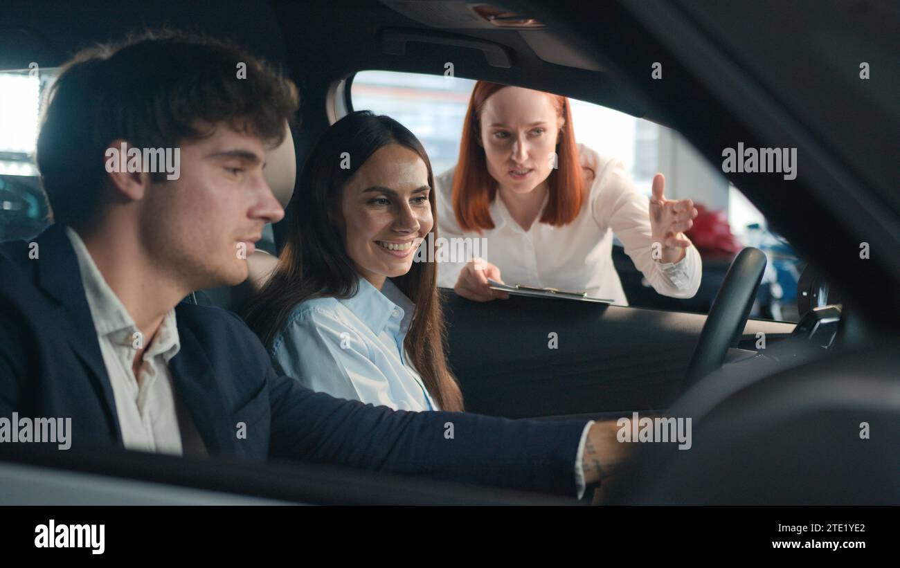 Caucasian cheerful married couple sitting in dream new car and ...