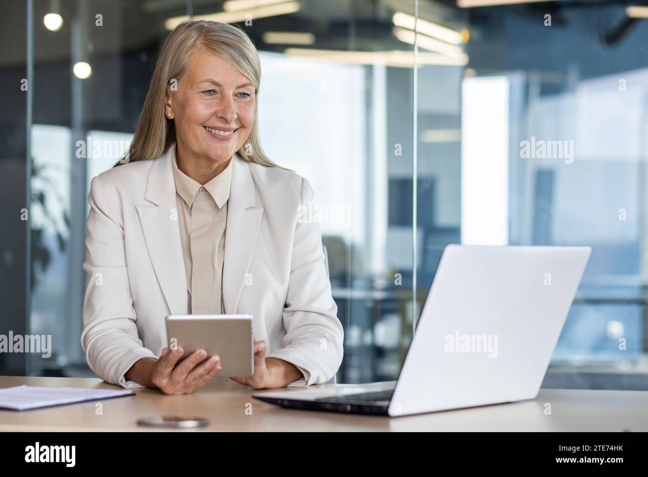 Woman boss at workplace inside office, senior experienced gray-haired ...