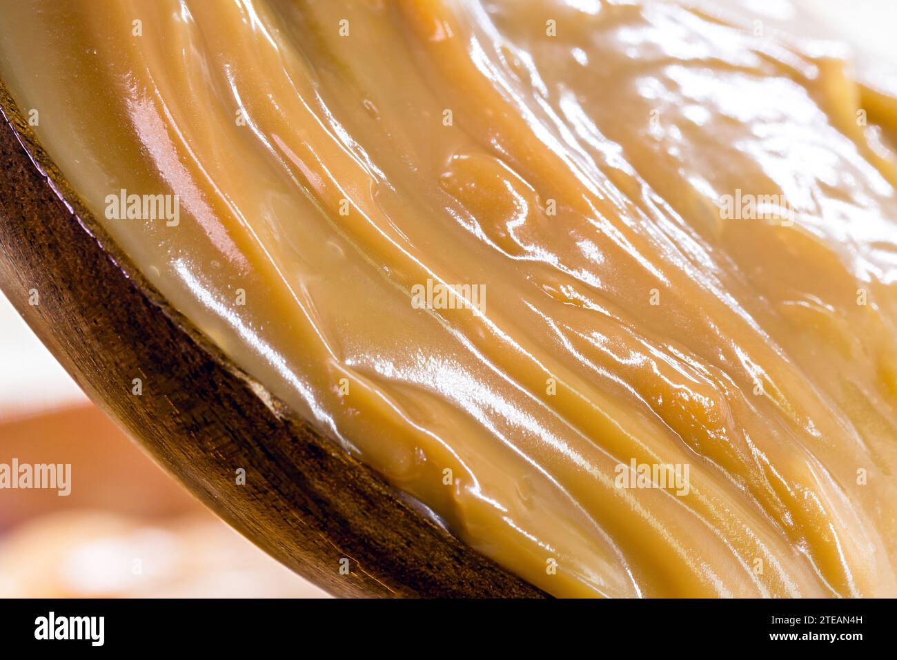 vegan dulce de leche or homemade caramel dripping from wooden spoon ...