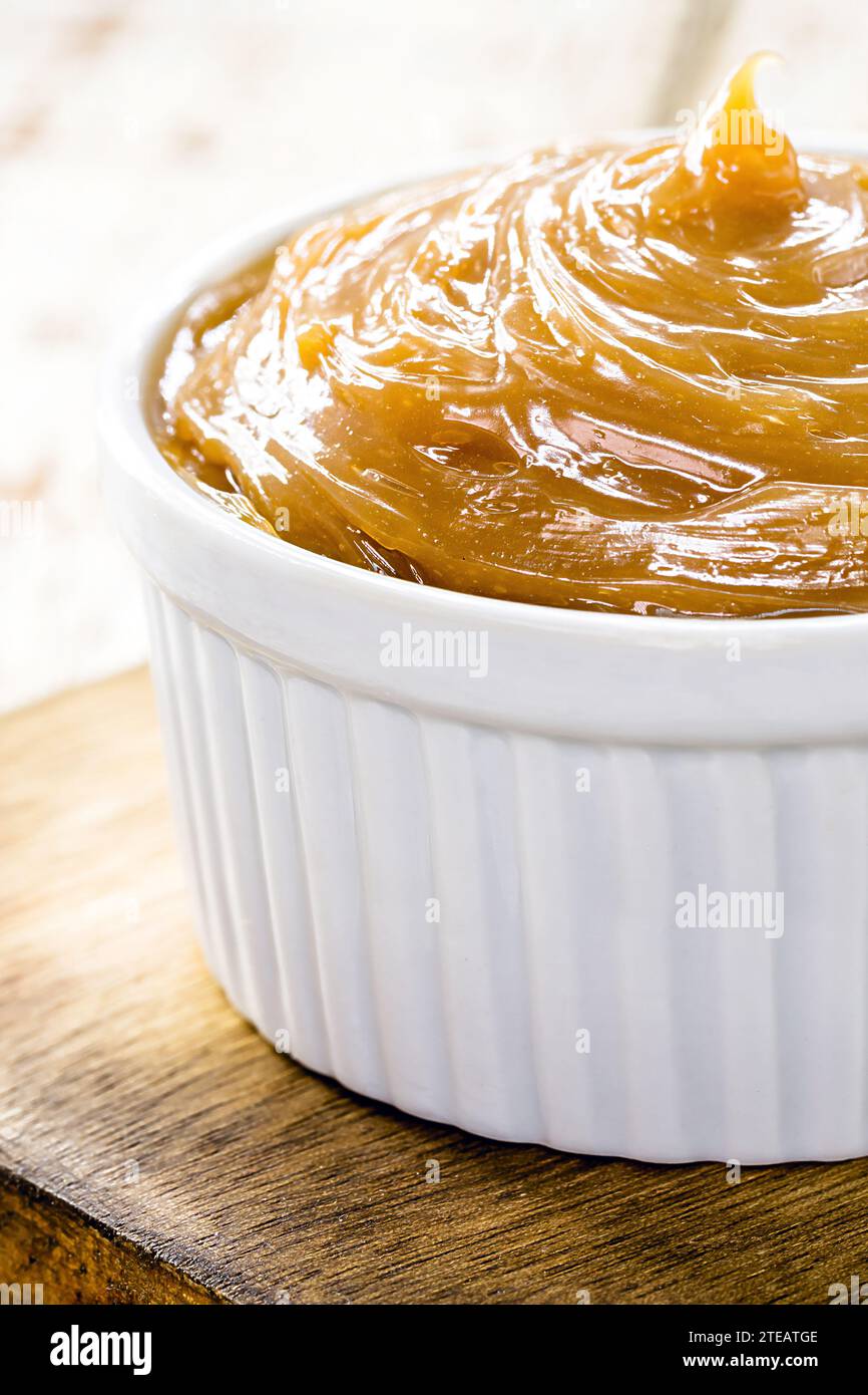 pot of dulce de leche or homemade caramel on rustic wooden background ...