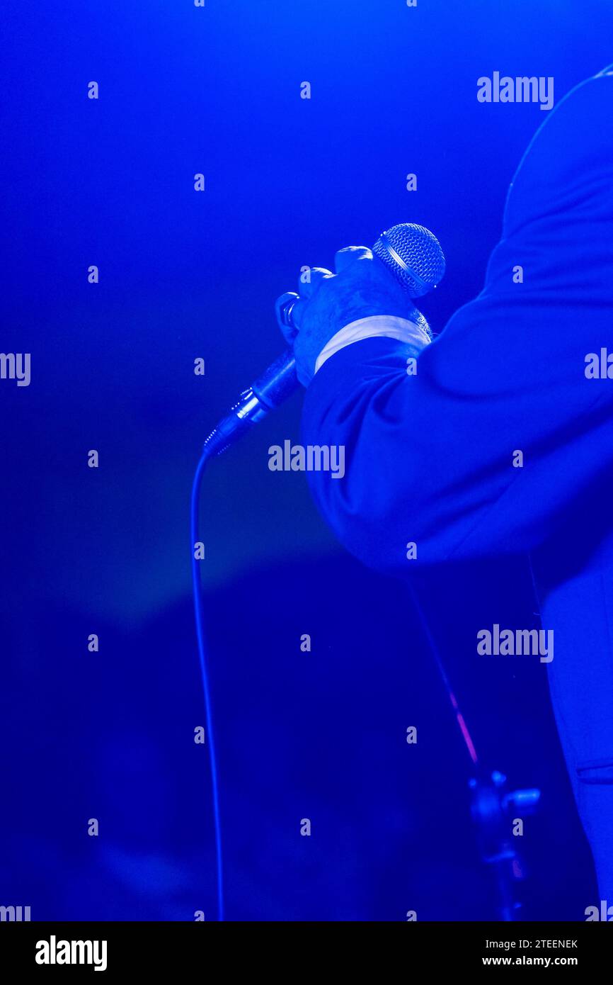 Dynamic singer performing under mesmerizing blue lights on stage Stock ...