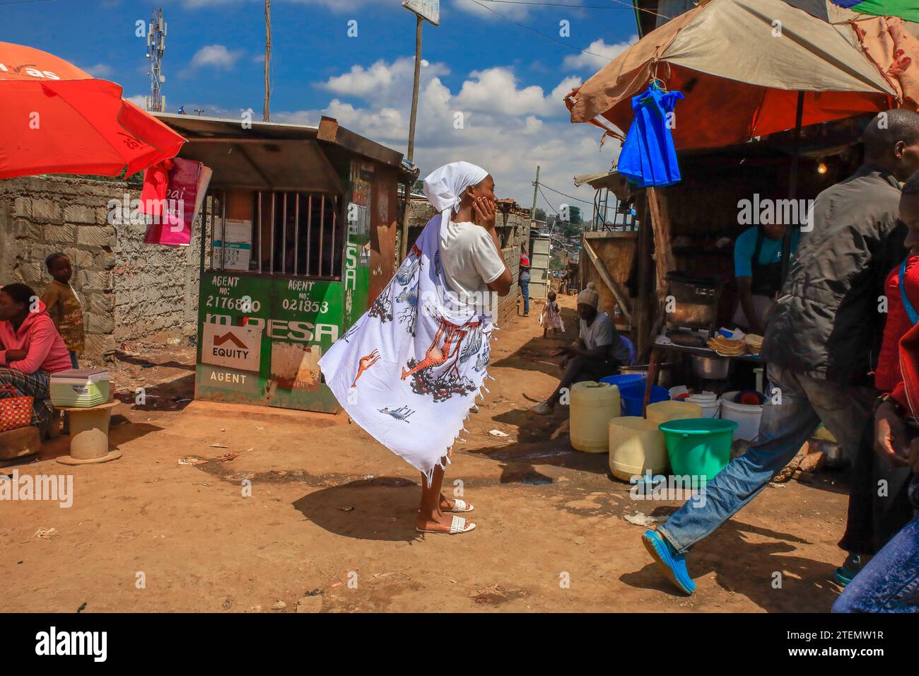 Residents walk past the busy streets in Kibera Slum, Nairobi. A view ...