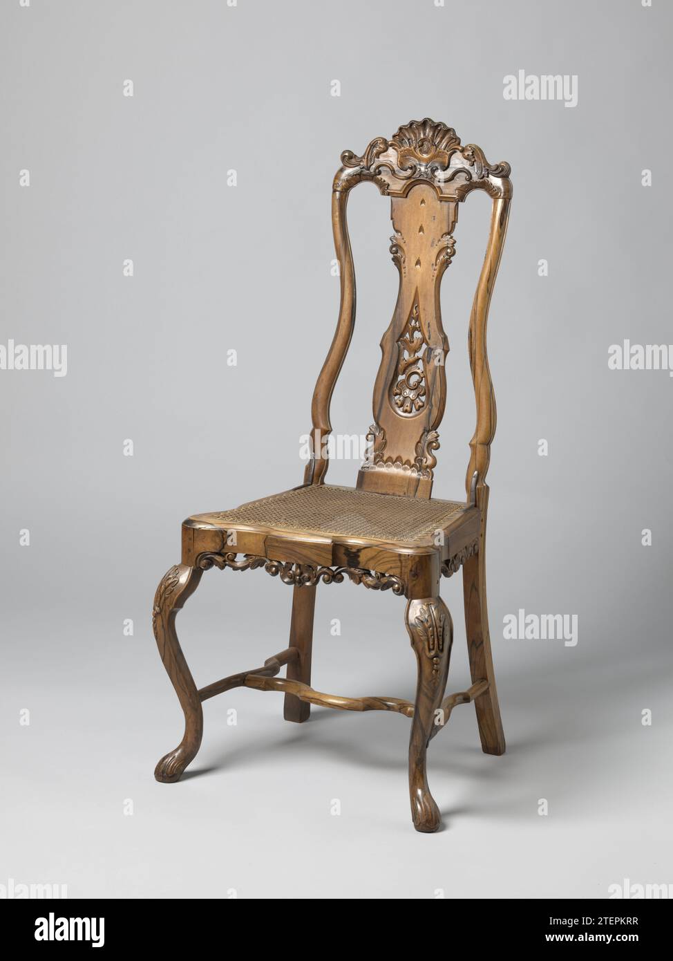 Chair with rattan seat. Cap with crest between s-shaped volutes and ...