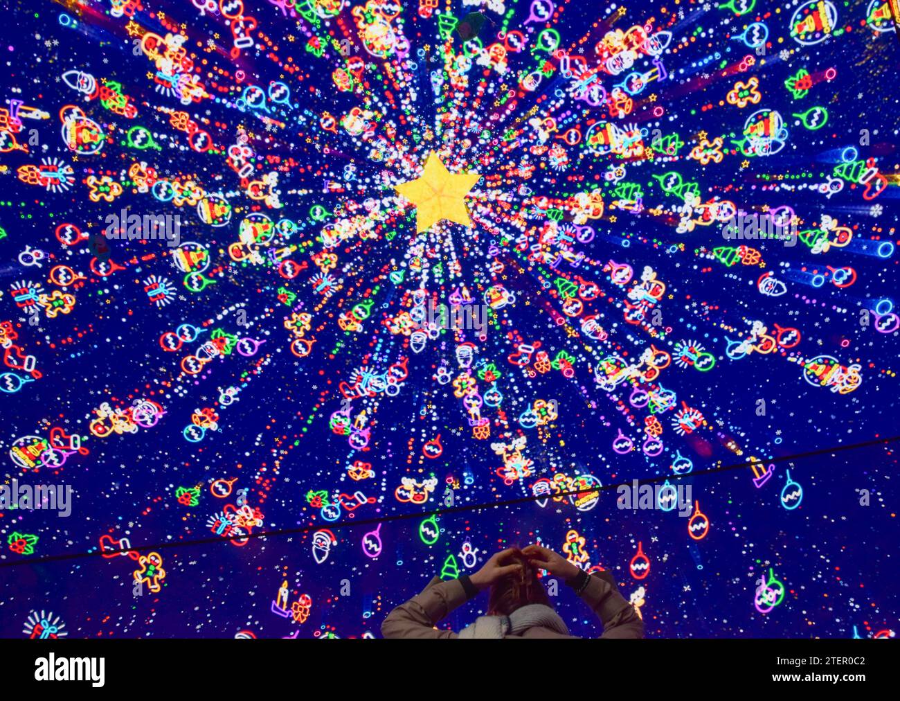 London, England, UK. 20th Dec, 2023. A visitor enjoys the Emoji Shower ...