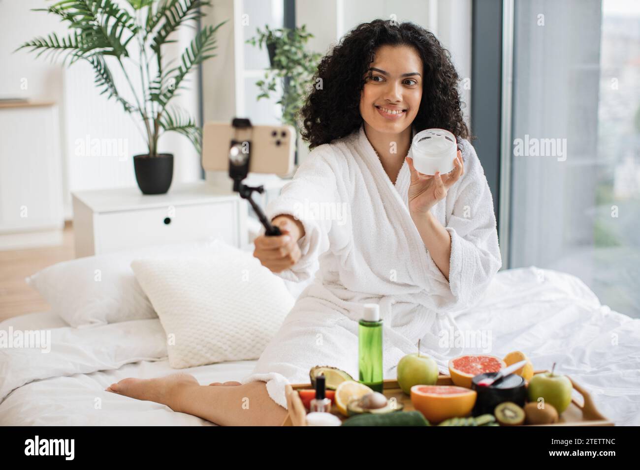 Beautiful young African woman social media influencer in bathrobe ...