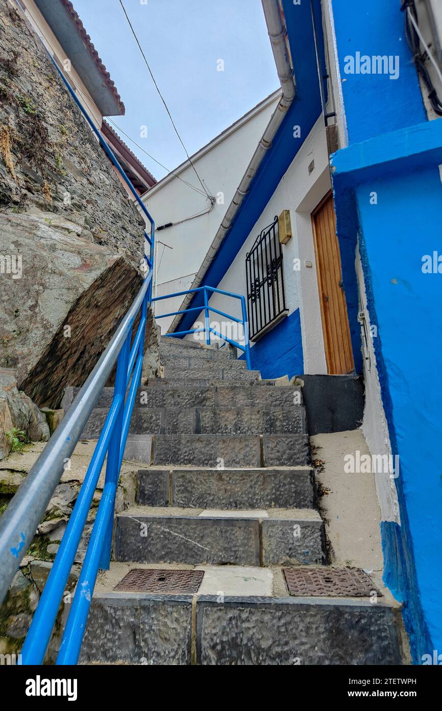 quaint staircase with blue railings leading to a charming white and ...