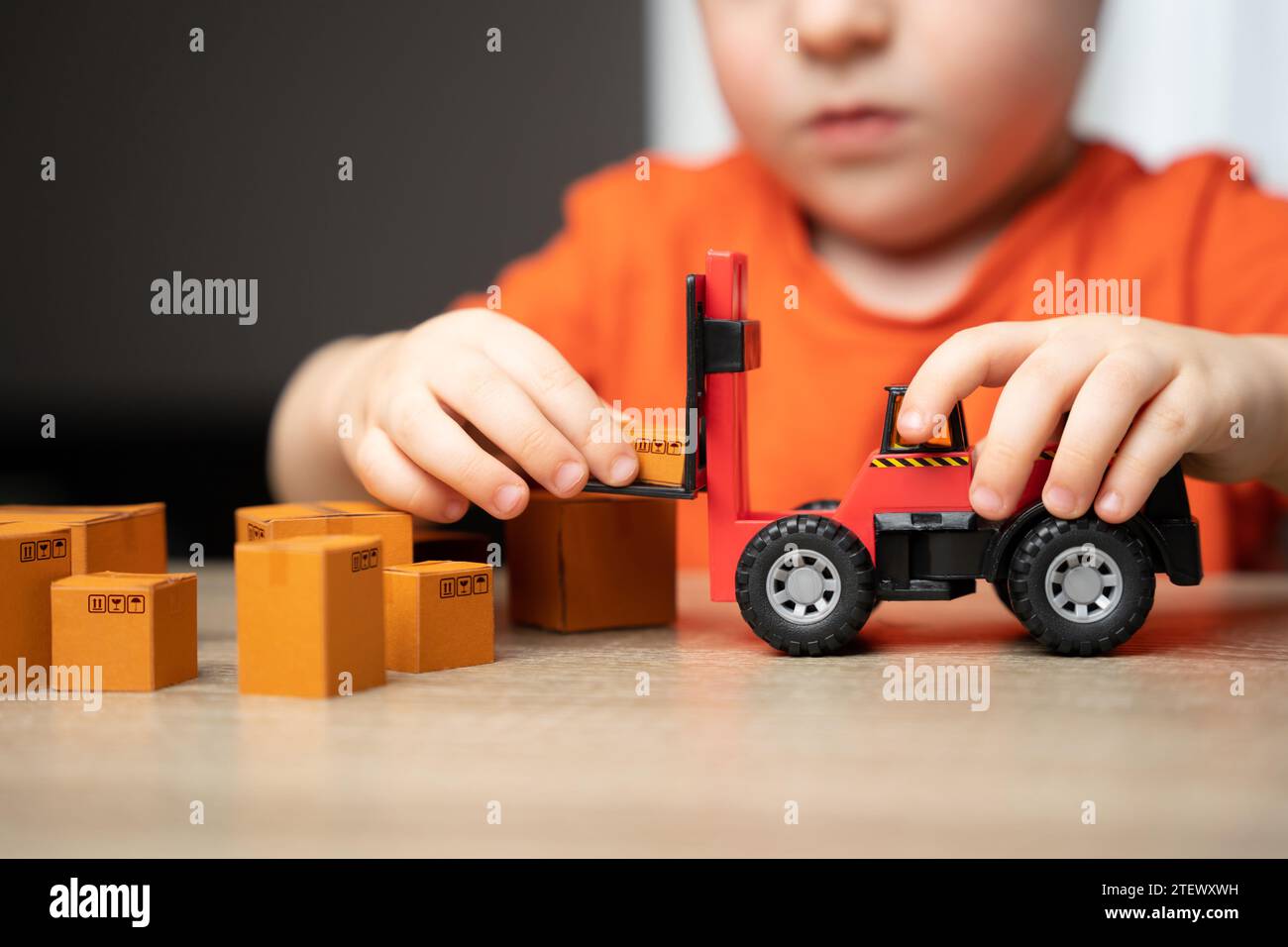 A child plays in loading boxes with a toy forklift. Warehouses ...