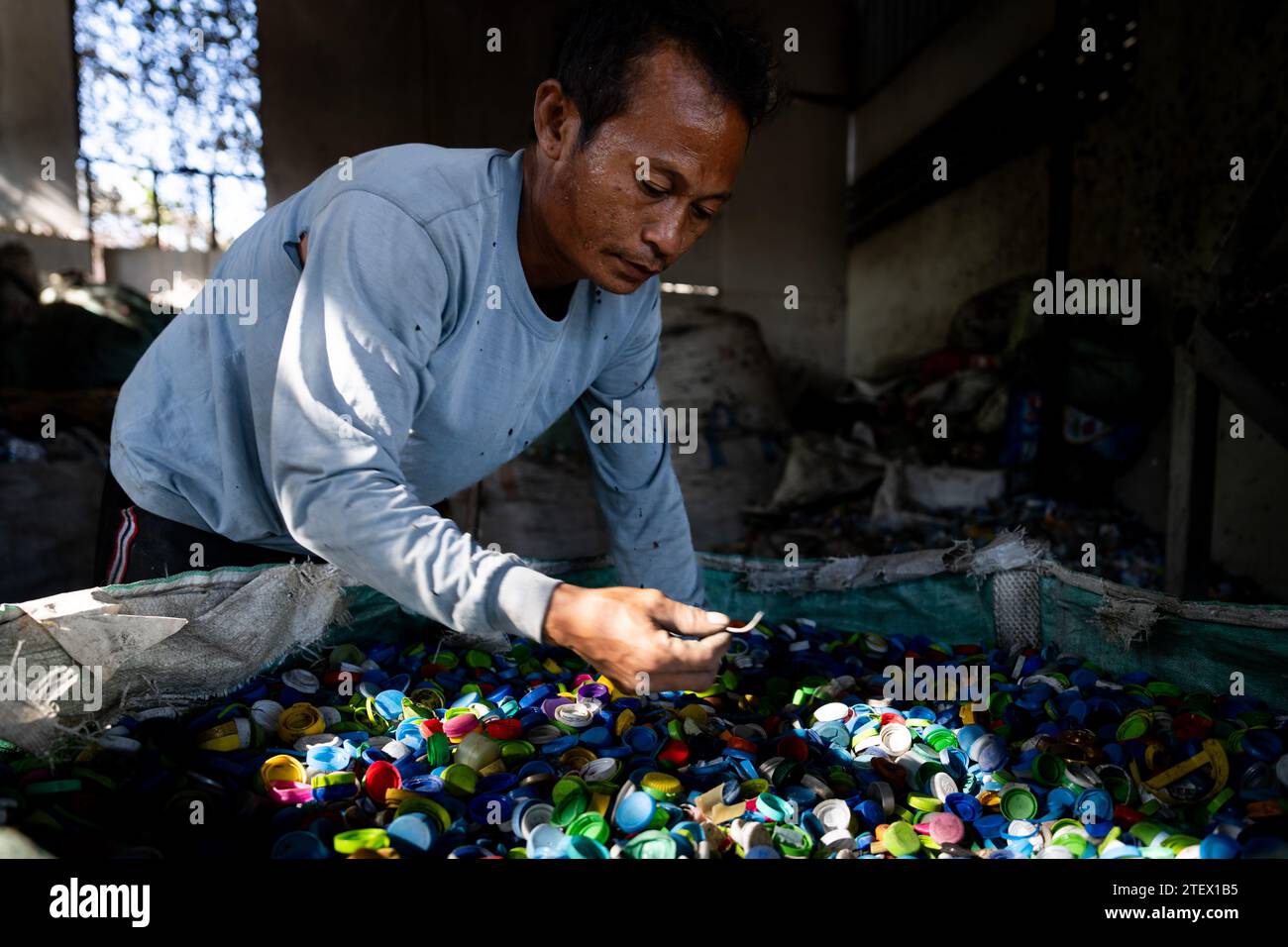 Bang Phli, Thailand. 20th Dec, 2023. A worker sorts plastic bottle caps ...